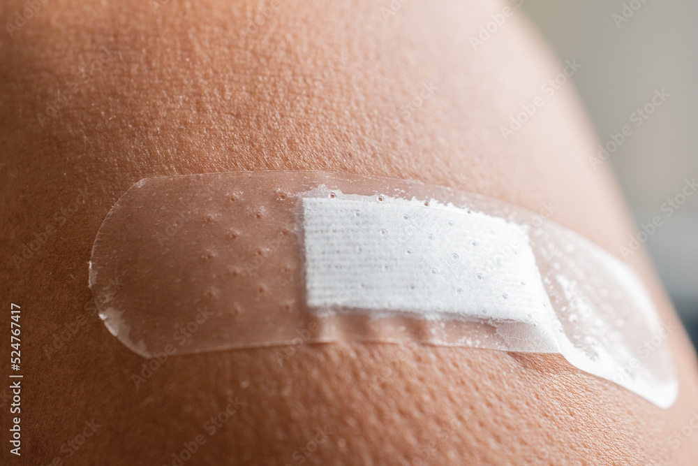 Medical adhesive plaster to stick wound on shoulder, arm close-up ...
