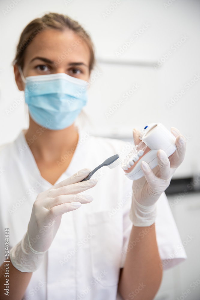 Foto de Portrait of confident dentist showing how to brush teeth on ...