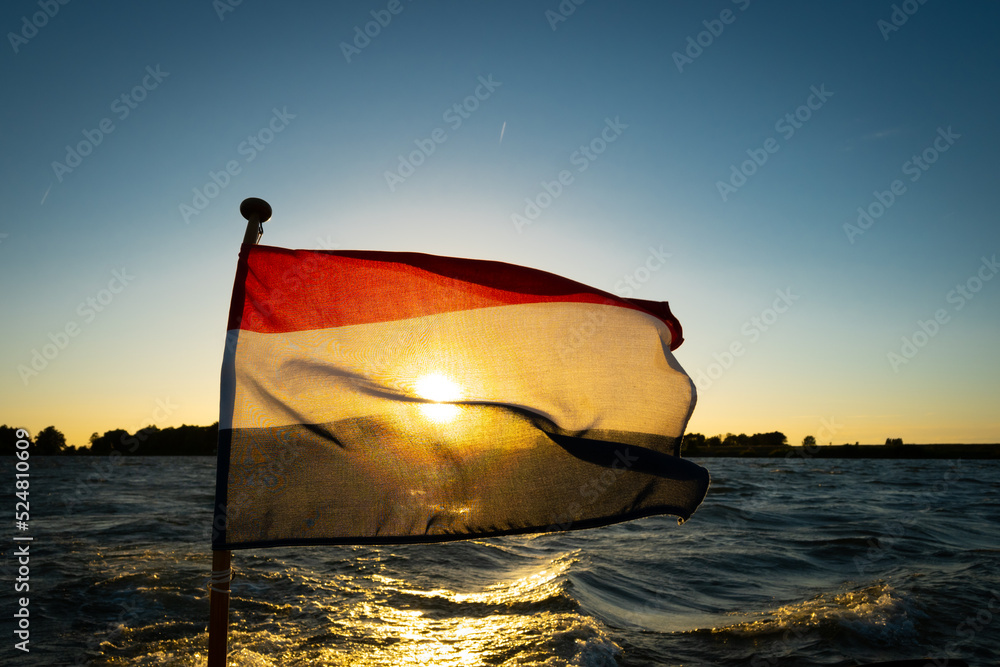 The Dutch flag flies proudly over the sun setting on the freshwater ...