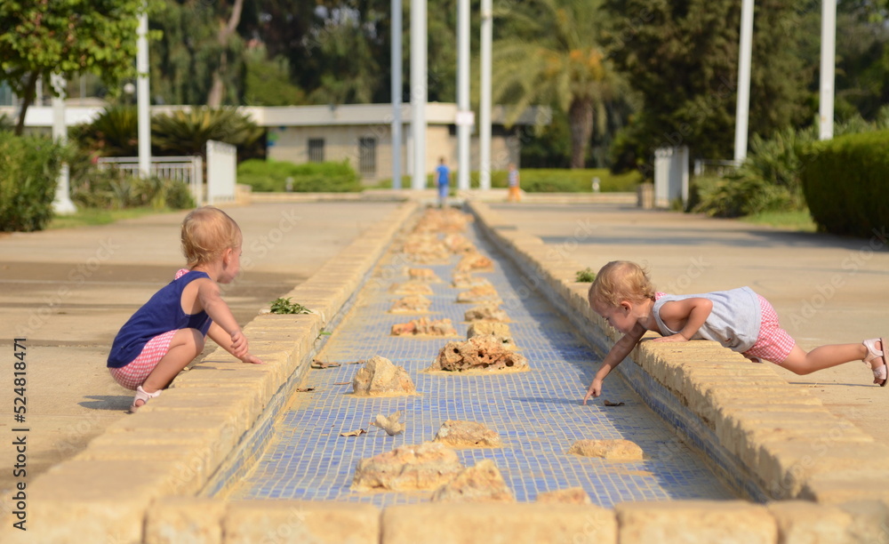 Twin girls. Sisters two years old. Cute positive kids play in the park ...