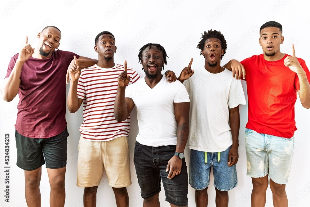 Young african group of friends standing together over isolated ...