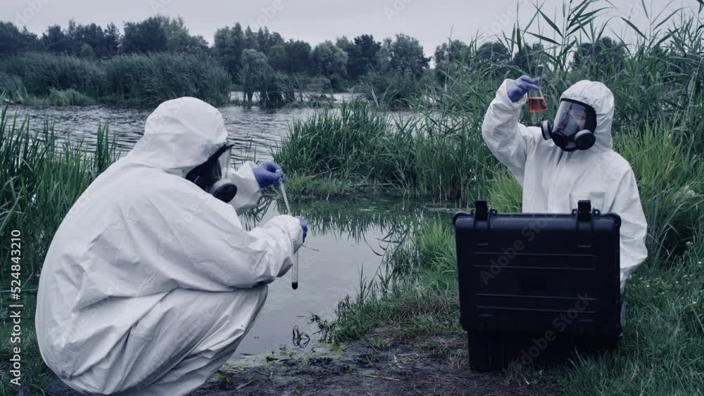 Video Stock Scientists in safety uniforms, sampling river water for ...