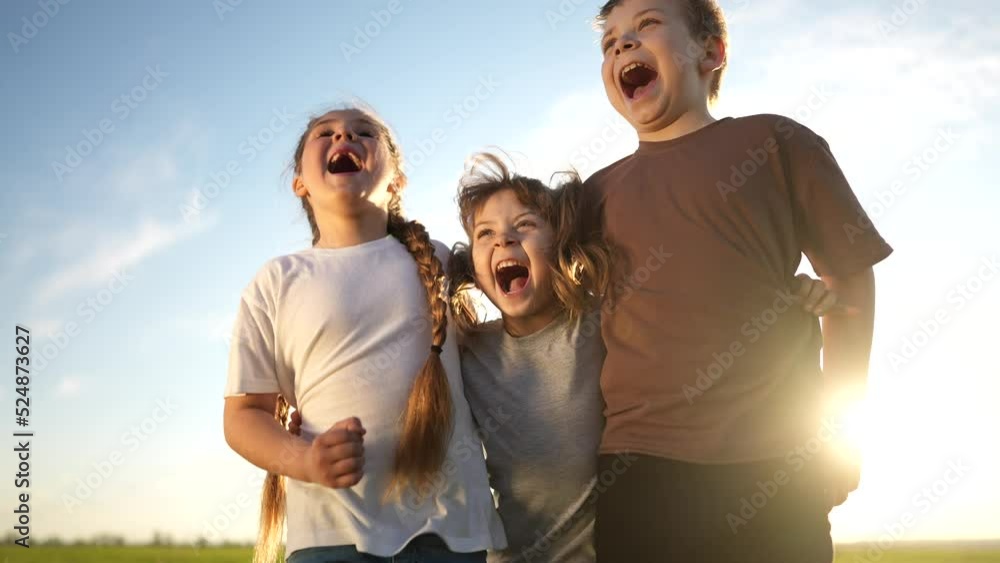 group of kids team hugging a jumping and rejoicing outdoors. happy ...