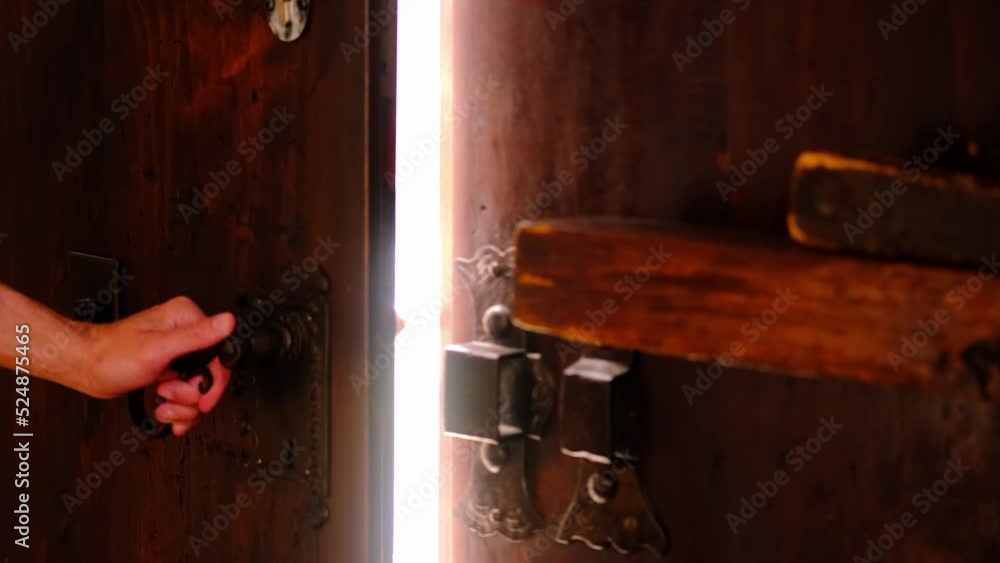 male hand opens heavy door, opening, closing old wooden door with metal ...