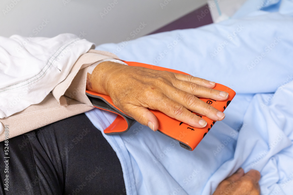 Hand in temporary fixture laying under blanket in emergency room inside ...