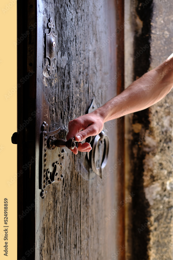 male hand opens heavy door, opening, closing old wooden door with metal ...