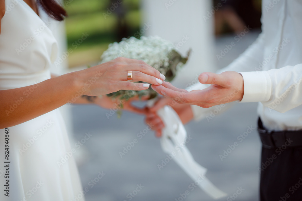 Wedding bouquet in the hands of the bride at the ceremony. Touching the ...