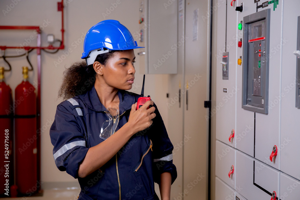 Electrical young asian woman engineer examining maintenance cabinet ...