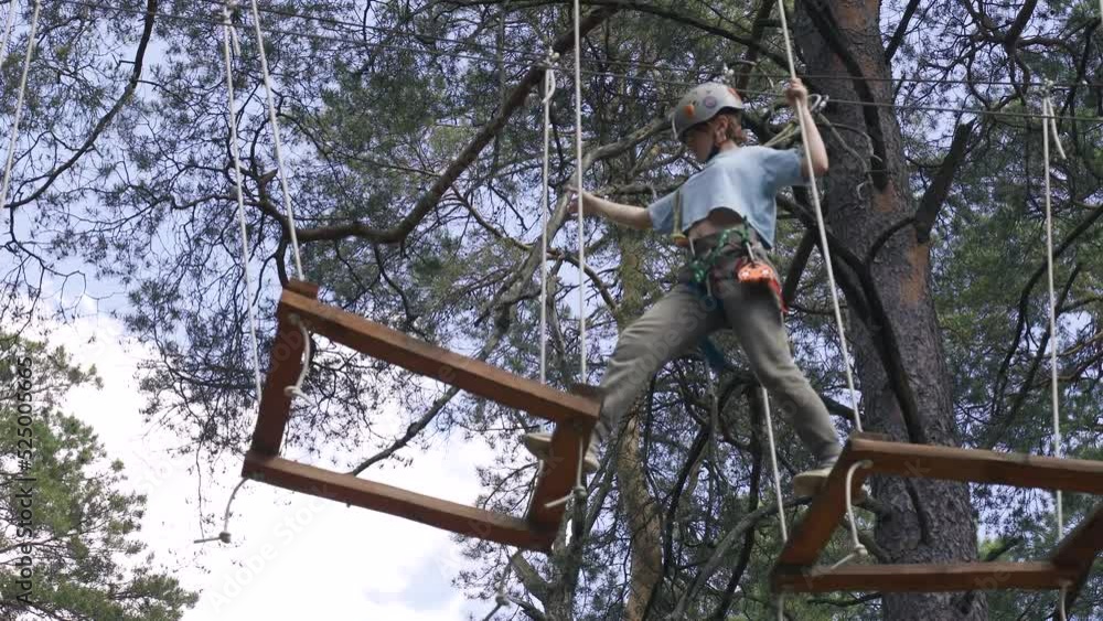 Brave teenage girl overcomes difficult obstacles while walking along a ...