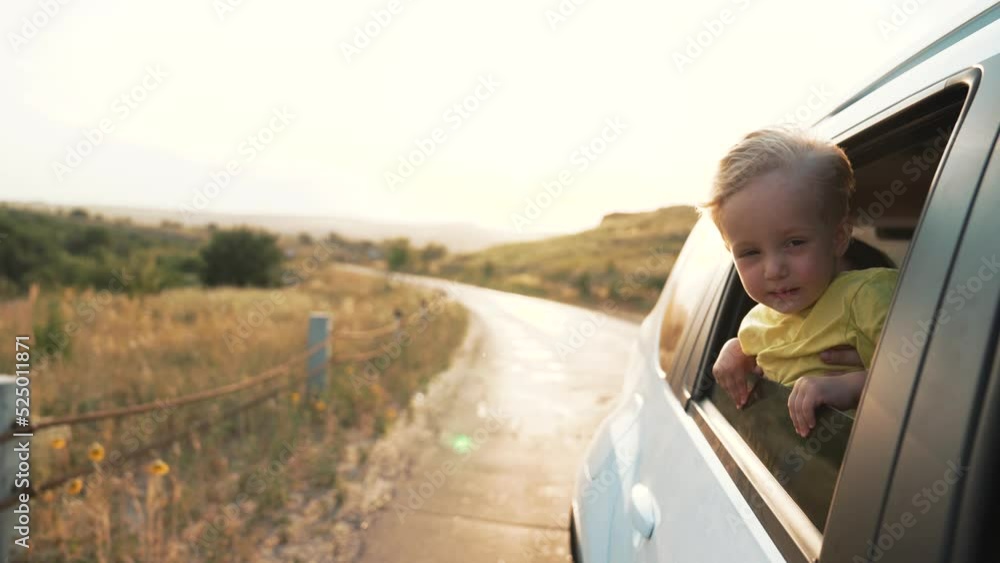 Teen boy looking out the car window and waving his hand. Family travel ...