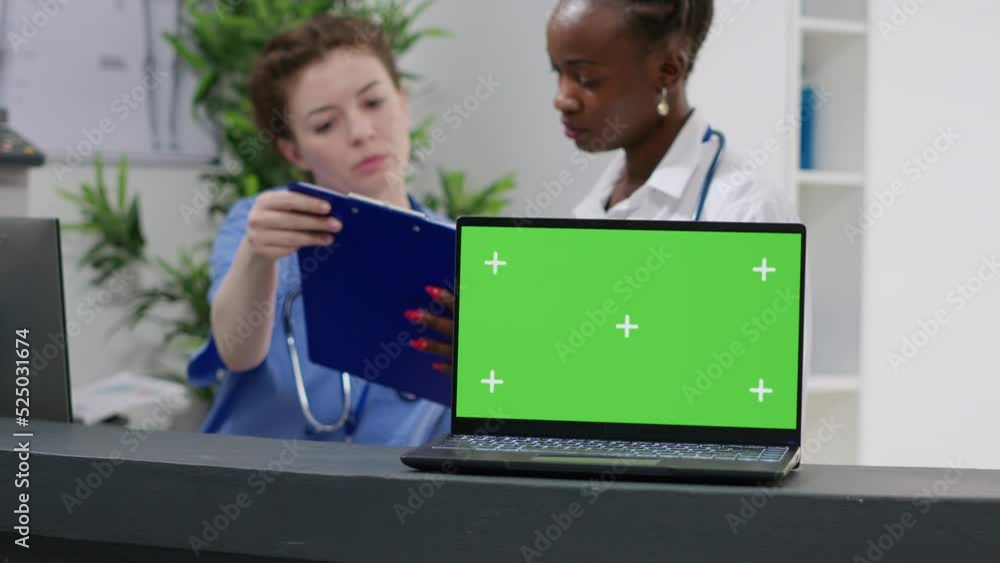 Laptop with greenscreen display on hospital reception counter used by ...