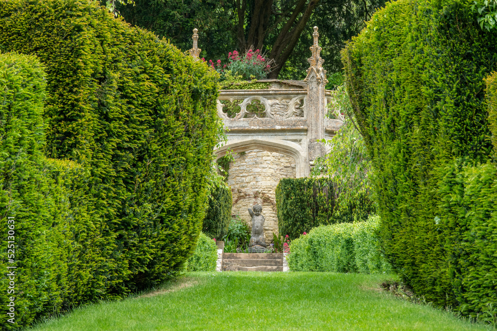 statue in front of old stone summerhouse in the Italian Garden at The ...
