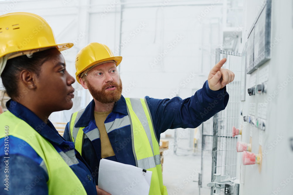 Confident technician or manager explaining female colleague how to ...