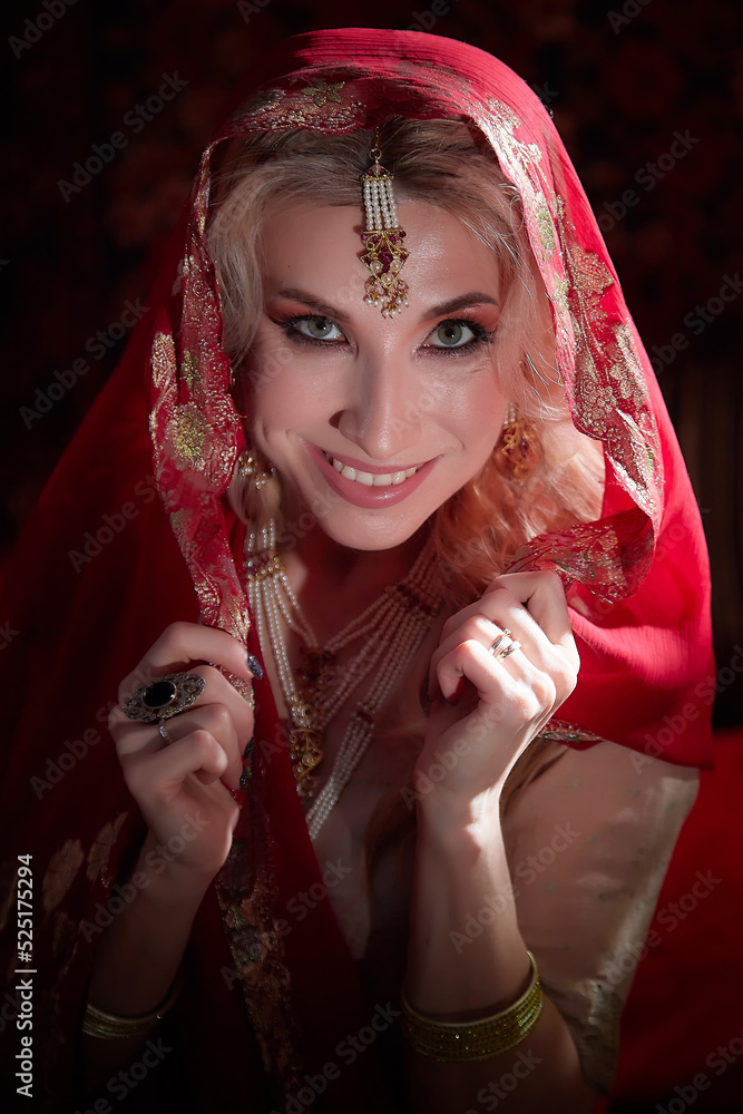 A beautiful European girl looking like an Arab woman in a red room in a ...