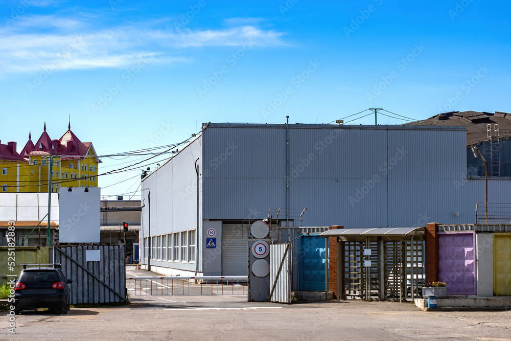 Industrial area. Barrier gate at entrance to industrial area. Factory ...