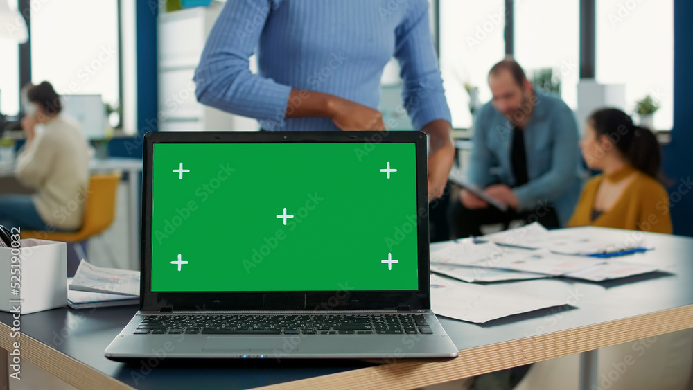 Laptop computer with green screen on desk in front of african american ...