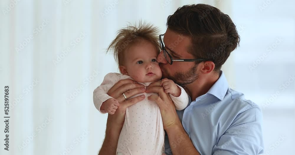 Caring young father feeling love kisses his cute newborn daughter ...