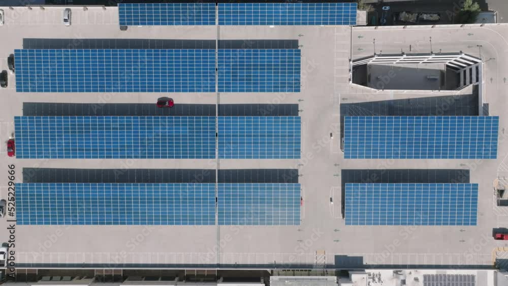 Top down view car driving between rows of blue solar batteries on ...