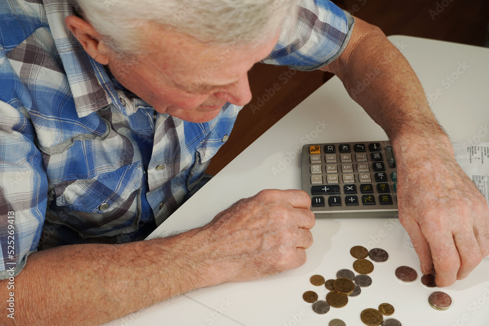 Upset depressed Senior man sitting at the table and calculating ...