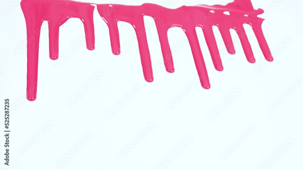 pink paint drips down the white surface, melting drops forming streaks ...