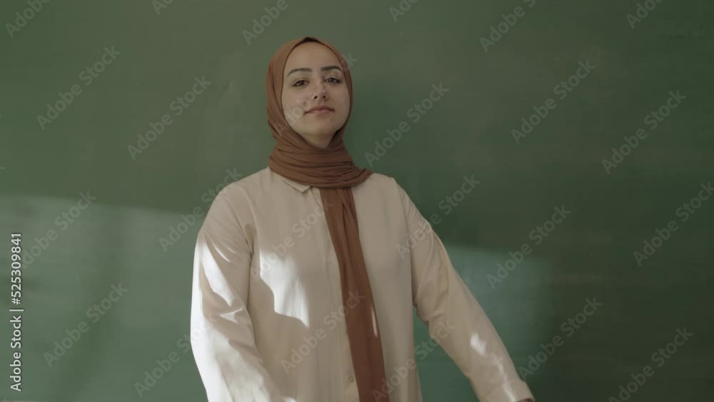 Portrait of muslim female teacher smiling at camera in front of ...