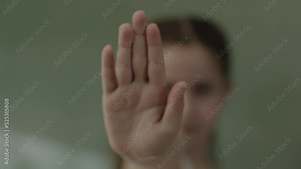 Little girl makes a stop sign with her hand and says stop to social ...