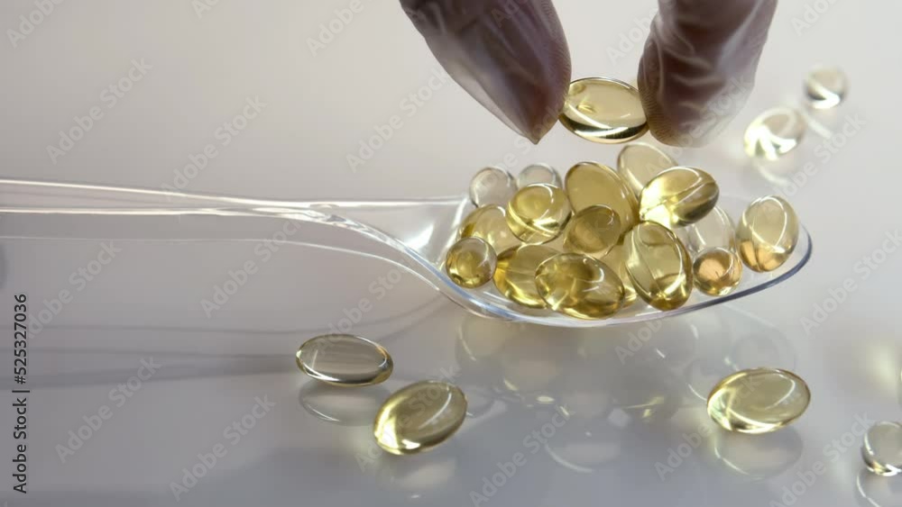 Gelatin capsules with a transparent composition close-up. Hand in a ...