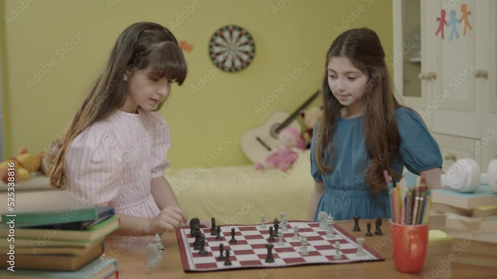 Vidéo Stock Portrait of smart little girls playing chess in their room ...