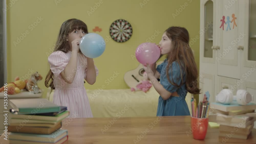 Little girls are blowing air into the balloon. Happy birthday party ...