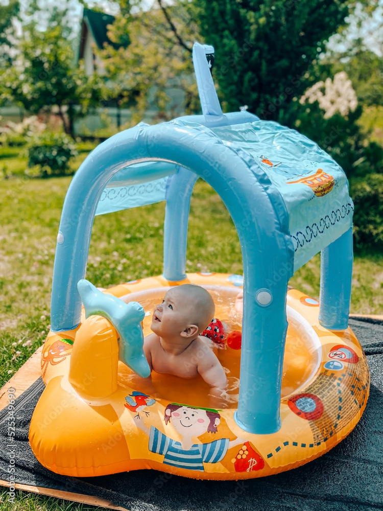 Cute baby boy in the small swimming pool in the garden smiling Stock ...