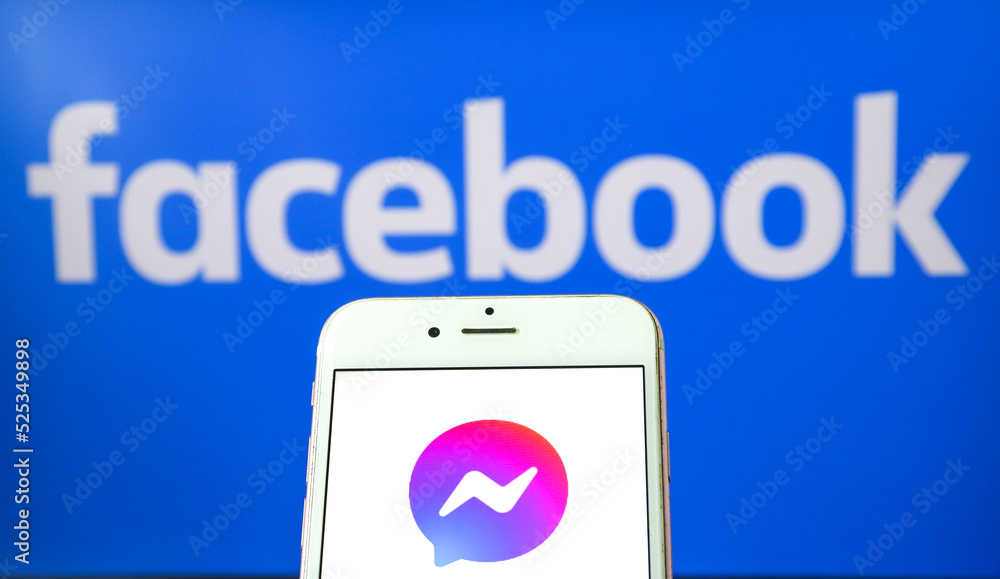 Facebook messenger logo on phone screen and Facebook logo background on ...