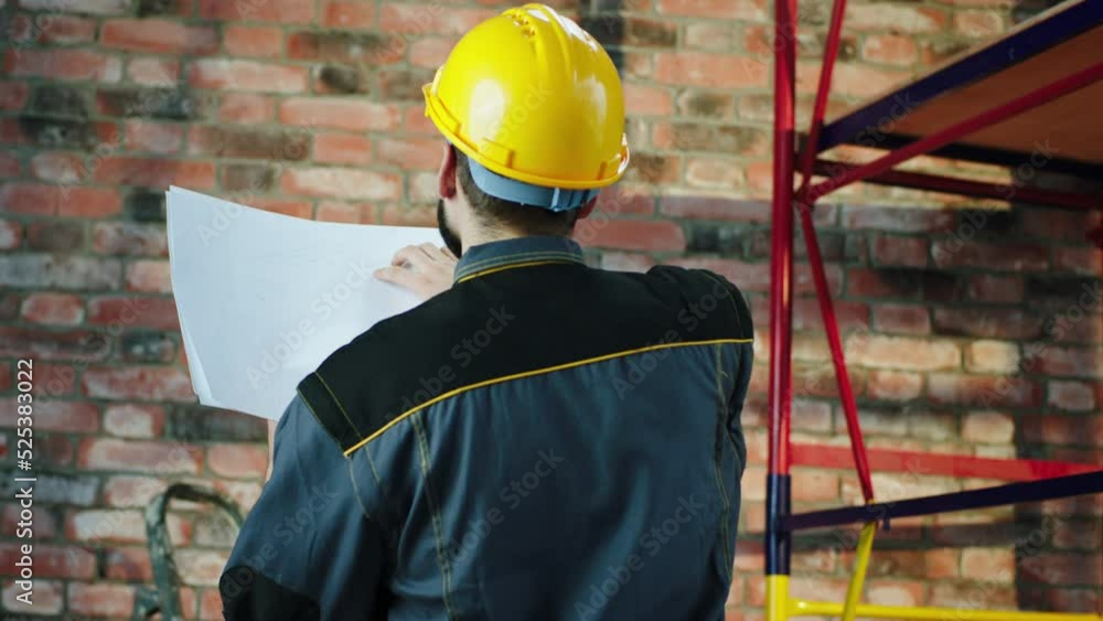 Concentrated working foreman at construction site he using the plan of ...