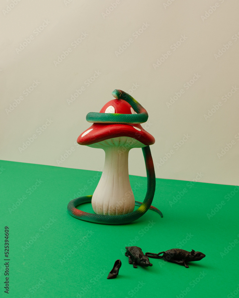Snake wrapped around a big mushroom and mice under it on green ...