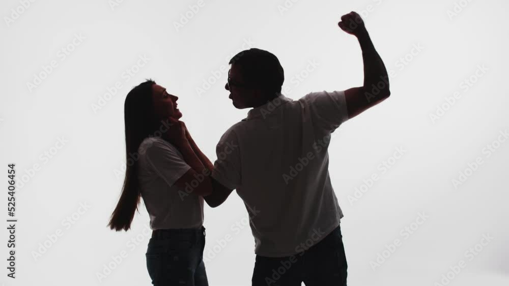 Silhouette of a family couple fighting. Man grabs woman by her neck and ...