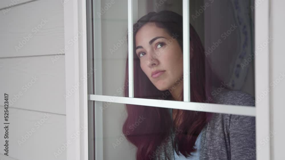 Sad, depressed woman in house looks up into the distance with sad ...
