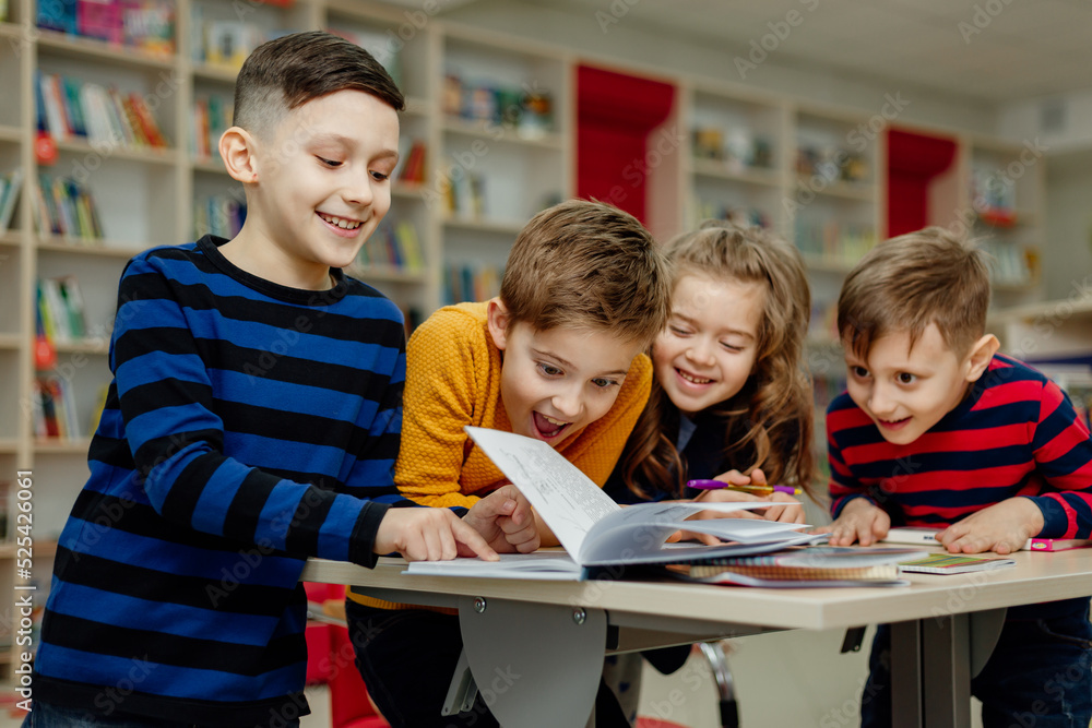 school children in the library reading books, doing homework, prepare a ...