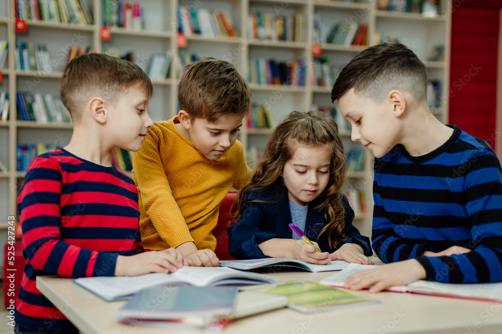 school children in the library reading books, doing homework, prepare a ...
