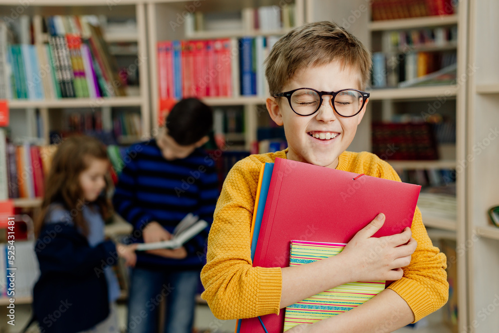school children in the library reading books, doing homework, prepare a ...