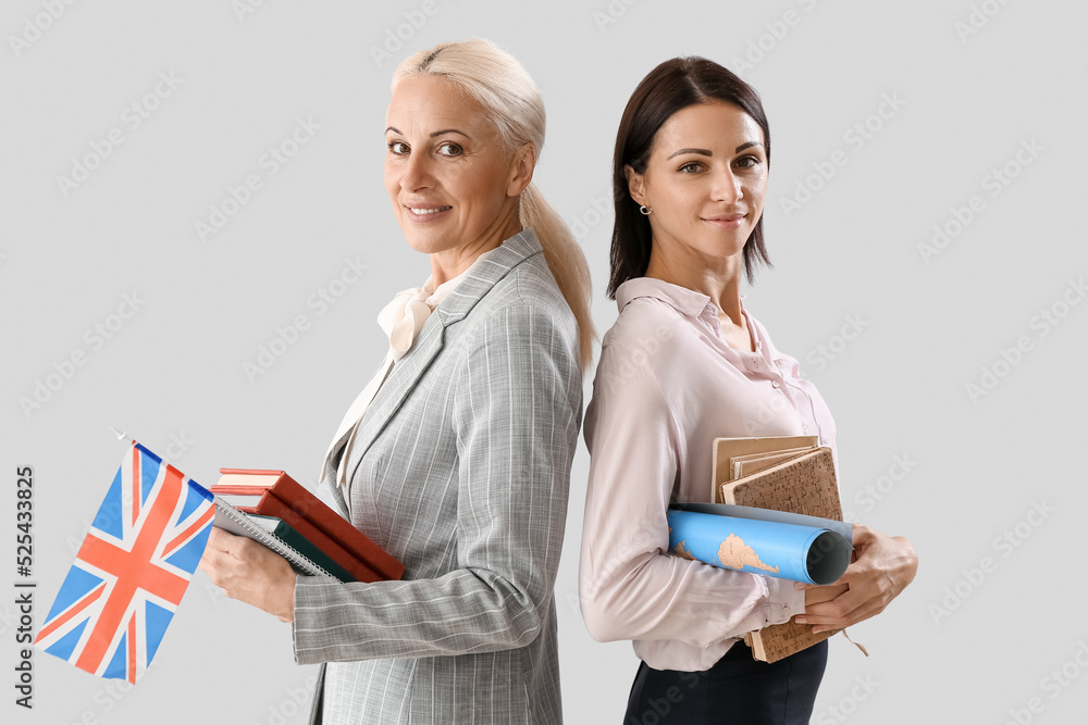 Female teachers with UK flag and books on light background Stock Photo ...