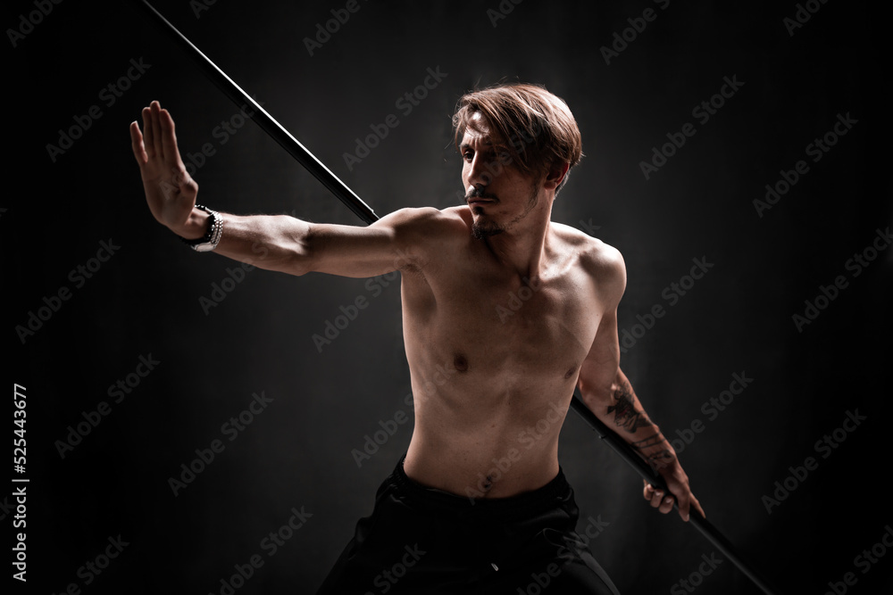 Asian man fighter practices martial arts on black background. Kung fu ...