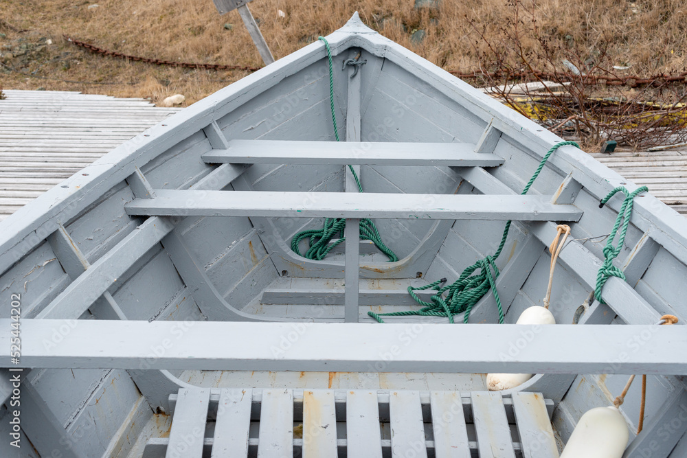 A grey wooden row boat with a gray interior is on a wooden slipway. The ...