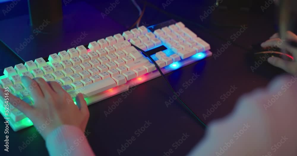 Close up gamer hands actively pushing buttons with colorful neon LED ...