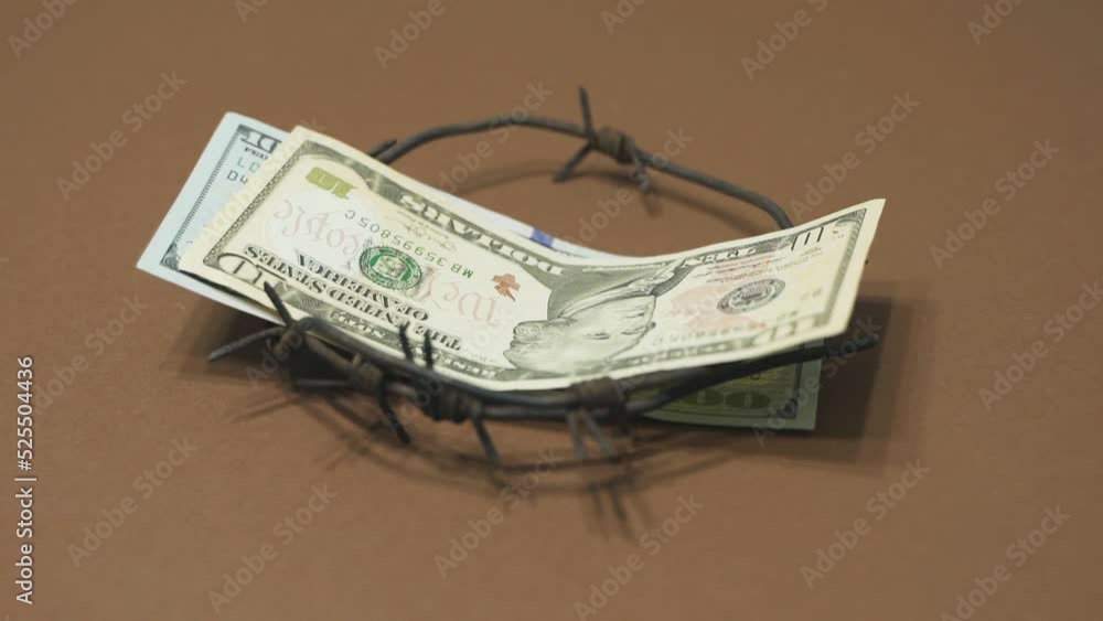 Dollars are placed in a circle of barbed wire. Symbol of corruption ...