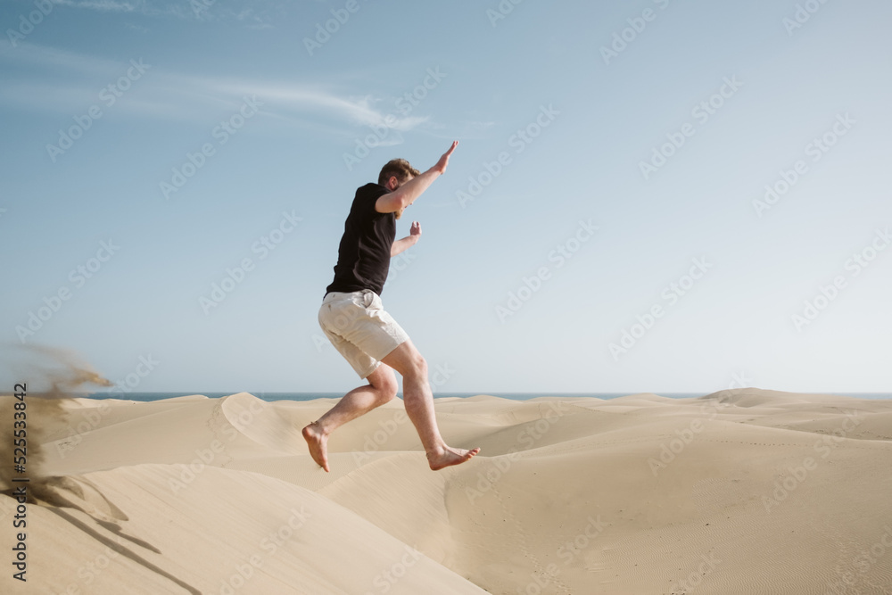 Man jumping on sand land and blue sky Stock Photo | Adobe Stock