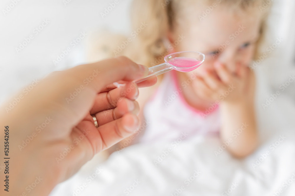 The child refuses to drink syrup when sick. Stock Photo | Adobe Stock