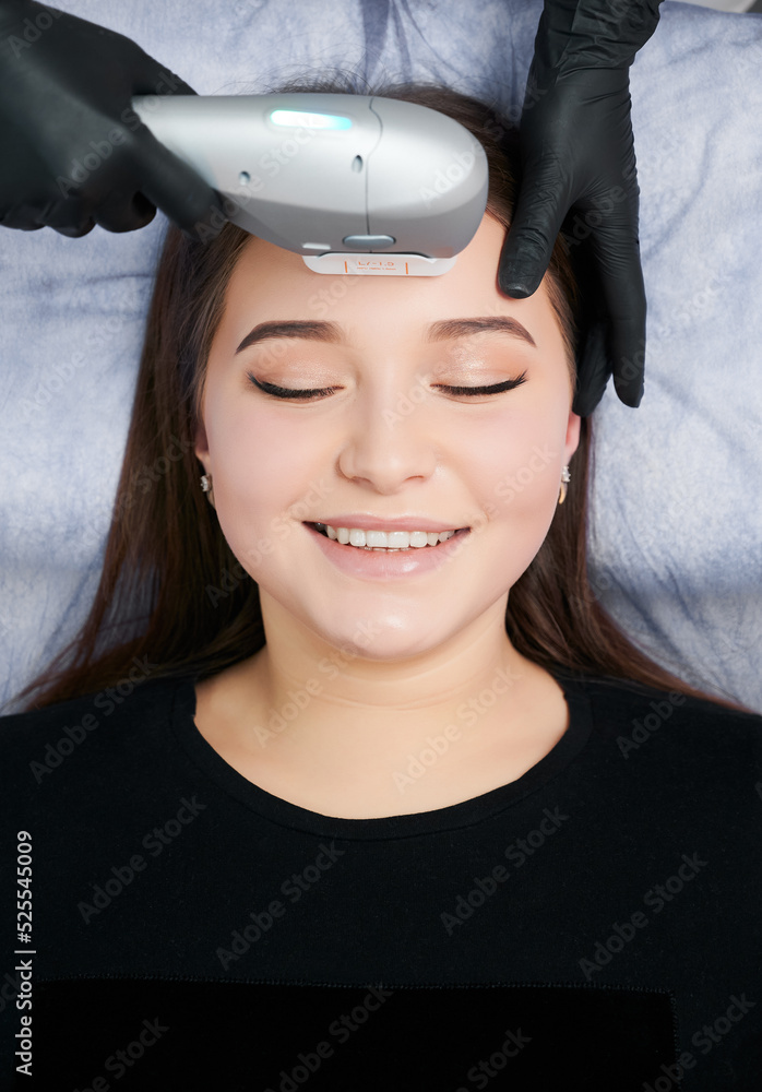 Top view of beautiful young woman with closed eyes having face lifting ...