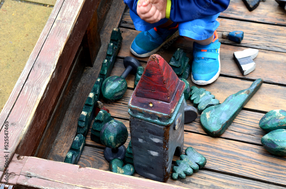 a little boy plays with a wooden building block. construction urbanism ...
