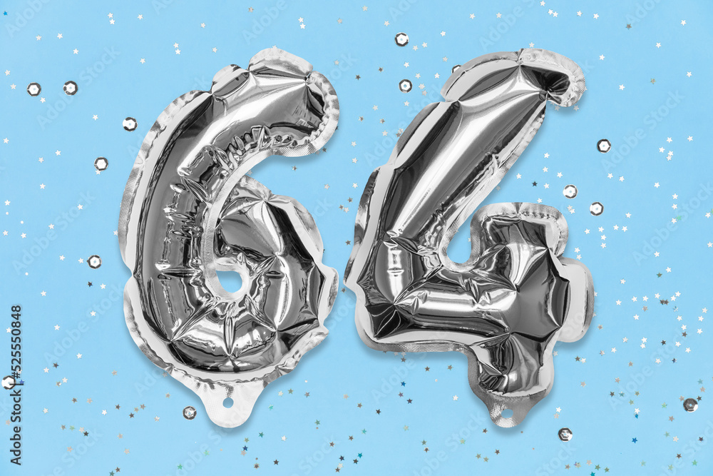 Silver foil balloon number, digit sixty four on a blue background with ...