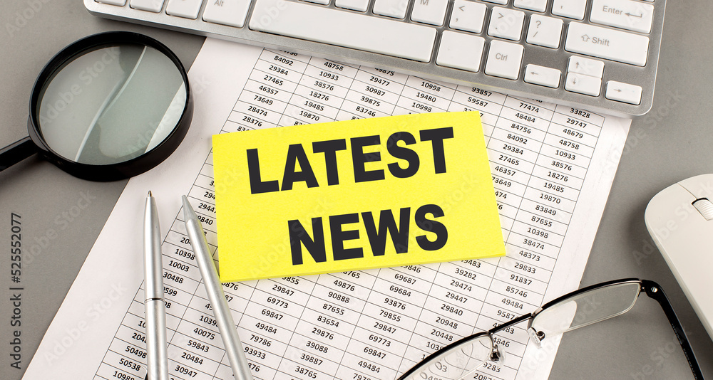 LATEST NEWS text written on a sticky on chart with keyboard and ...