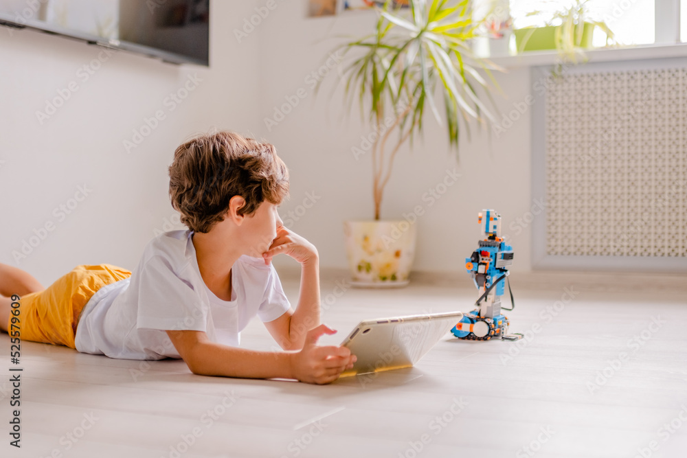 Kid programming robot from plastics details and programmed on tablet ...